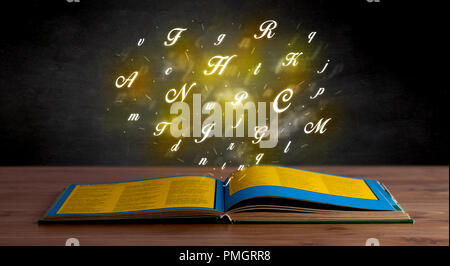 Glowing yellow alphabet letters coming out of an open book Stock Photo ...