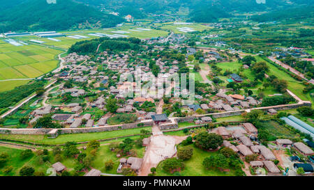 An aerial view of a traditional house with a thatched roof. People ...