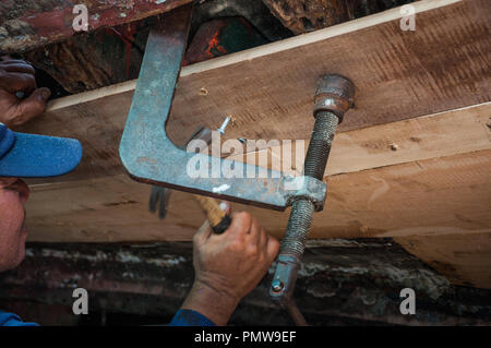 Mechanic maintenance old wood boat on beach with hand, fishery ...
