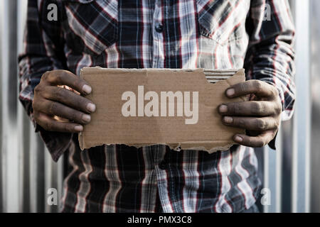 A homeless beggar holding a blank cardboard sign Stock Photo - Alamy