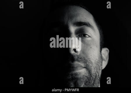 dramatic portrait in the dark of attractive depressed and worried man ...