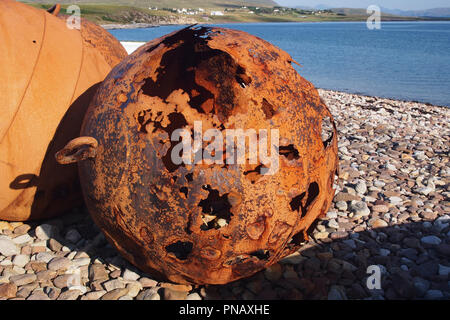 A view of broken, large, discarded iron sea floats on Badentarbat beach ...