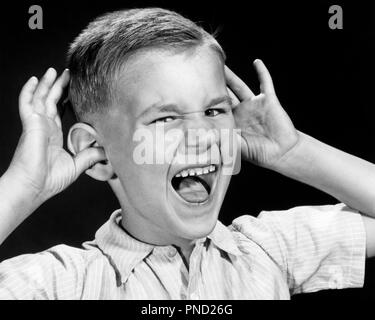 Portrait of kid boy mocking and teasing at someone showing finger at ...
