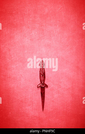 Red Wicca wiccan dagger on a red textured background with space for ...