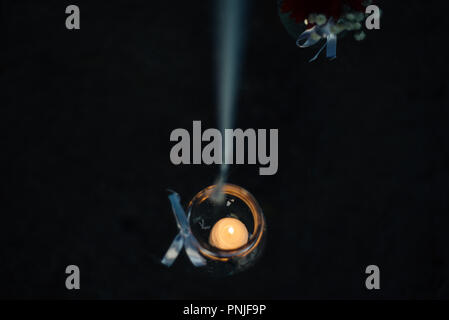 candles hanging from an oak light up the garden at night for party ...