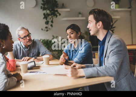 Group of coworkers having a meeting in a cafe Stock Photo - Alamy