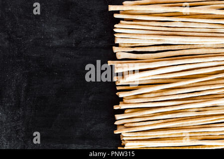 top view of breadsticks grissini torinesi on blackboard background ...