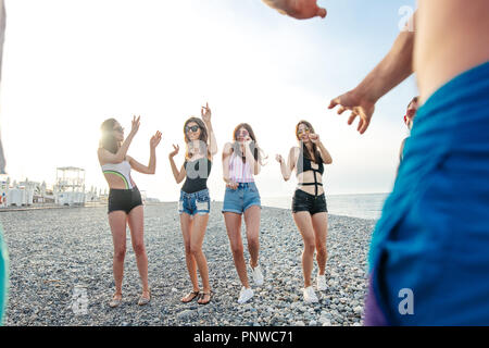 Friends dance on beach under sunset sunlight, having fun, happy, enjoy ...