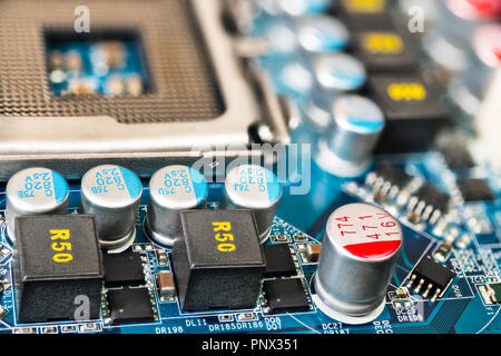 Circuit board detail with inductors or capacitors on black background ...