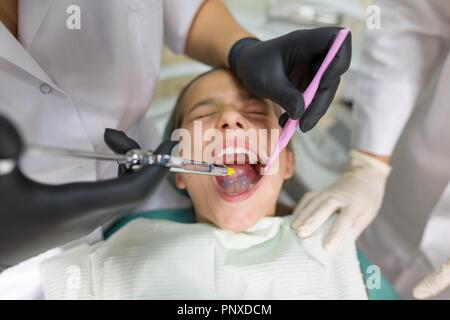 Dentist use anesthetic injection for tooth extraction in child Stock ...