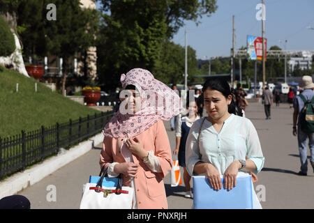 Two Uzbek women walking in street in a village near Samarkand in ...