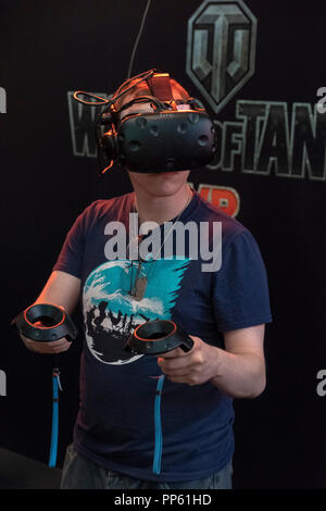 Visitor with virtual reality glasses and controllers at the World of ...
