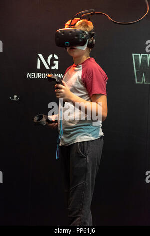 Visitor with virtual reality glasses and controllers at the World of ...
