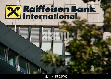 A logo sign outside of the headquarters of Raiffeisen Bank ...