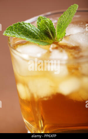 Brandy glass with ice on green background Stock Photo - Alamy