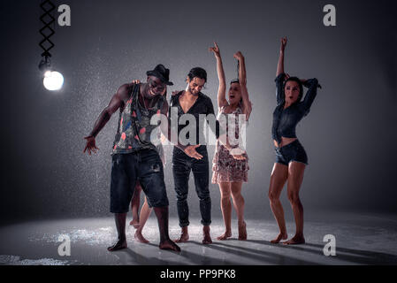 Group of friends dancing under the rain - Multiethnic people having ...