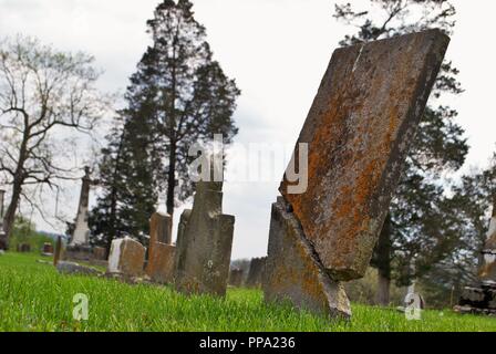 very old moss covered broken statue / headstone in a cemetery Stock ...