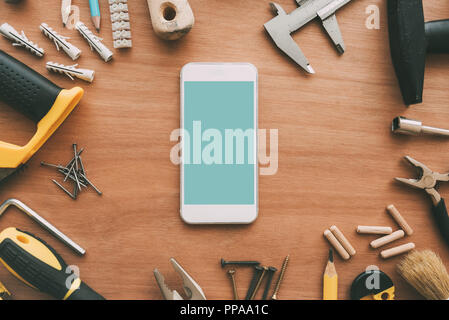 Flatlay handyman smartphone app with blank screen. Repairman using ...