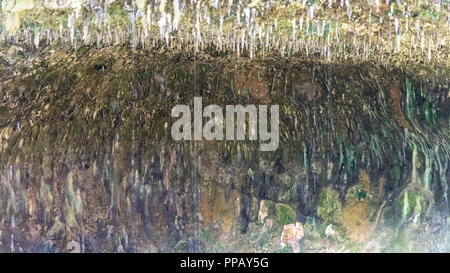 Behind a waterfall from inside a cave at Port Mora on the coastal path ...