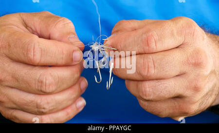 Man unraveling to the tangled and knotted Fishing line. Beginner ...