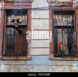 An old dirty and rusty pipe out of use against the cloudy grey sky ...