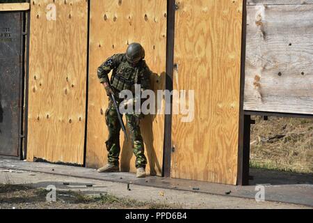 A Dutch Soldier uses an M500 shotgun to breach a door during the Urban ...