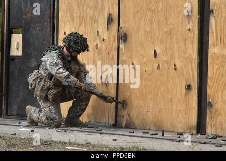 A Dutch Soldier uses an M500 shotgun to breach a door during the Urban ...