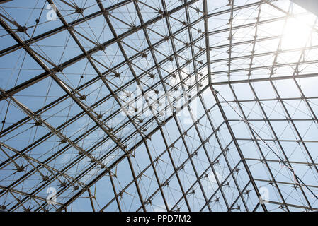 Louvre museum pyramid illuminated by sun rays at sunrise Stock Photo ...