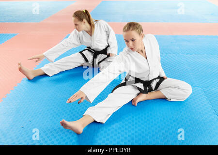 two karate girl sitting on the splits Stock Photo - Alamy