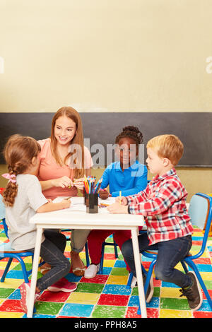 Multicultural group of children at the nursery school milk painting ...