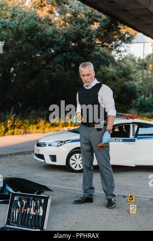 male police officer in latex gloves holding police line above head and ...
