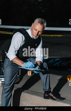 serious middle aged policeman in sunglasses talking on radio set in car ...