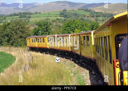 The small yellow trains of the Pyrenees crossing a beautiful mountain ...