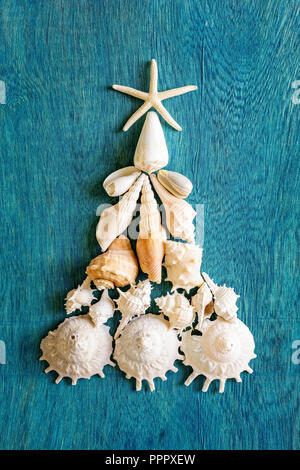 Christmas tree made from sea shells blue background with sparkles ...