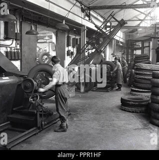 1950s, historical, male workers inside a warehouse filling up motor oil ...