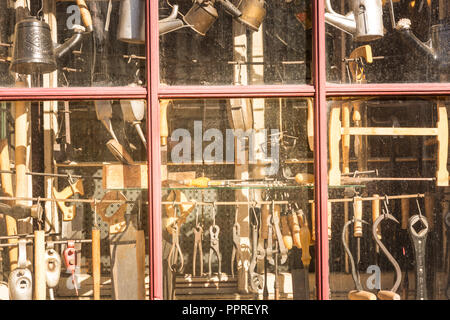 A hardware store shop window with a display of assorted tools ...