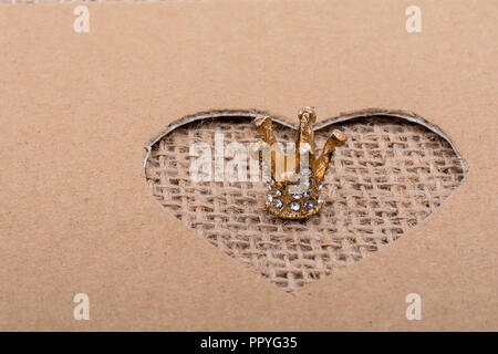 Crown seen through heart shape cut out of cardboard Stock Photo - Alamy