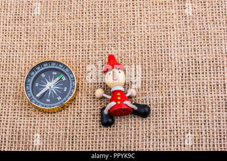 Figurine of pinocchio by the side of a compass Stock Photo - Alamy
