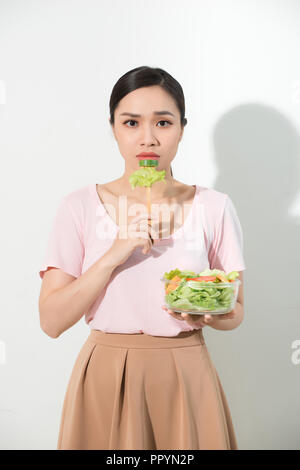 Sad woman eating vegetable salad in kitchen Stock Photo - Alamy