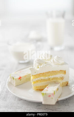 А piece of white cake with milk cream mousse and raspberry filling on a ...