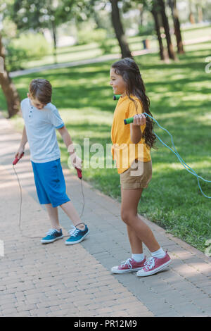 Cute happy children with jumping ropes on white background, collage ...