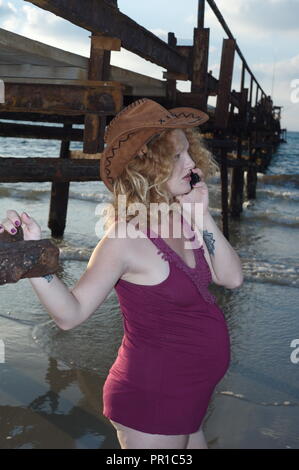 Young redhead woman talking on the phone with open hand doing stop sign ...