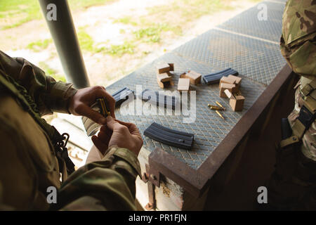 Military soldiers loading bullets in magazine Stock Photo - Alamy