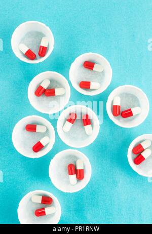 Painkillers pills in red and white capsules on dark background, macro ...