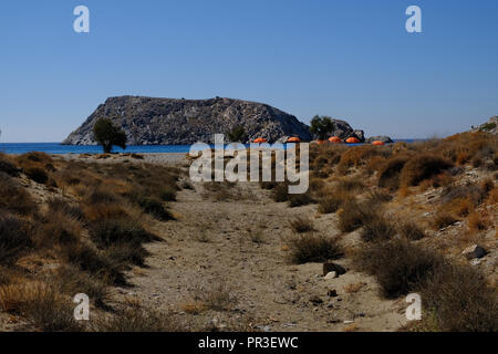 A beautiful view of dry beach umbrellas and chairs on a sandy beach ...