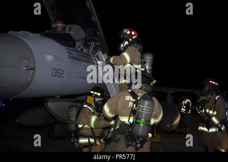 US Navy Firefighters remove the pilot of an F-A-18C Hornet during an ...