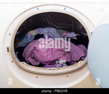 Washing machine porthole in the foreground with laundry inside Stock ...