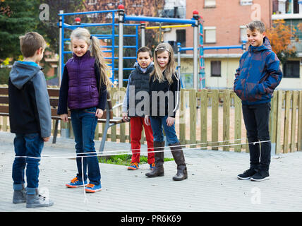 Happy children jumping game by rubber band and laughing Stock Photo - Alamy