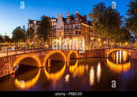 Illuminated bridge over the canals at night, Amsterdam, Netherlands ...