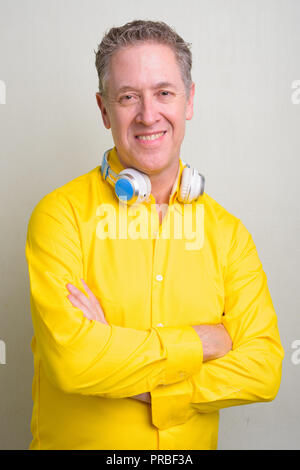 Portrait of mature businessman wearing yellow shirt Stock Photo - Alamy